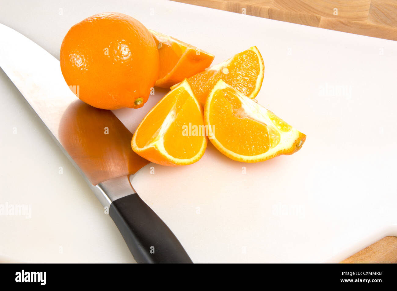 Freshly cut oranges with knife on white cutting board Stock Photo - Alamy