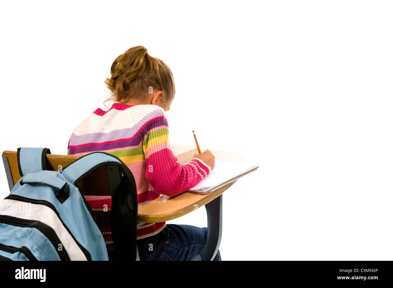 Young female student doing school work at desk with backpack on white ...