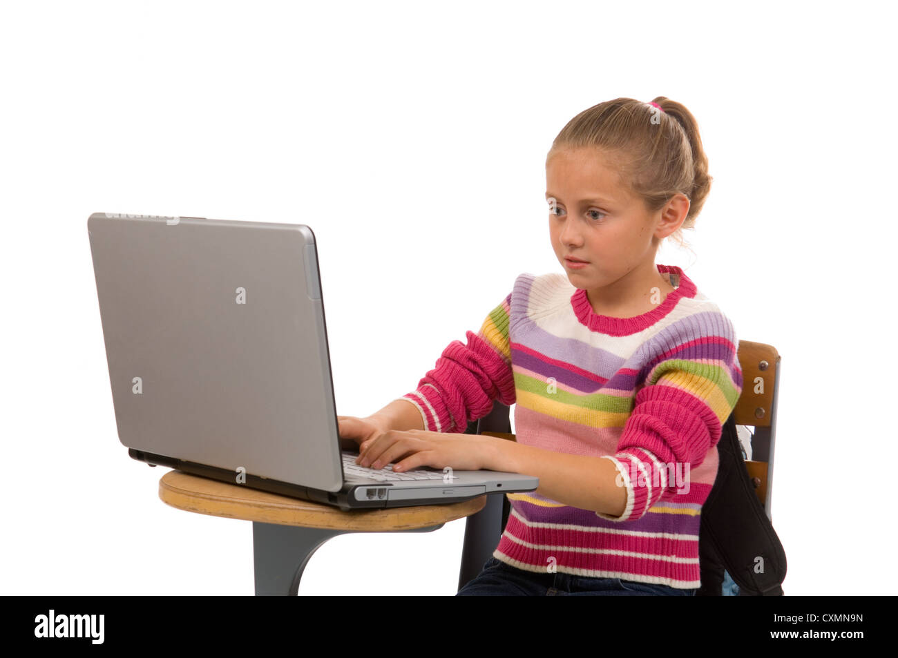 Young, cute female student working on laptop computer at school desk on ...