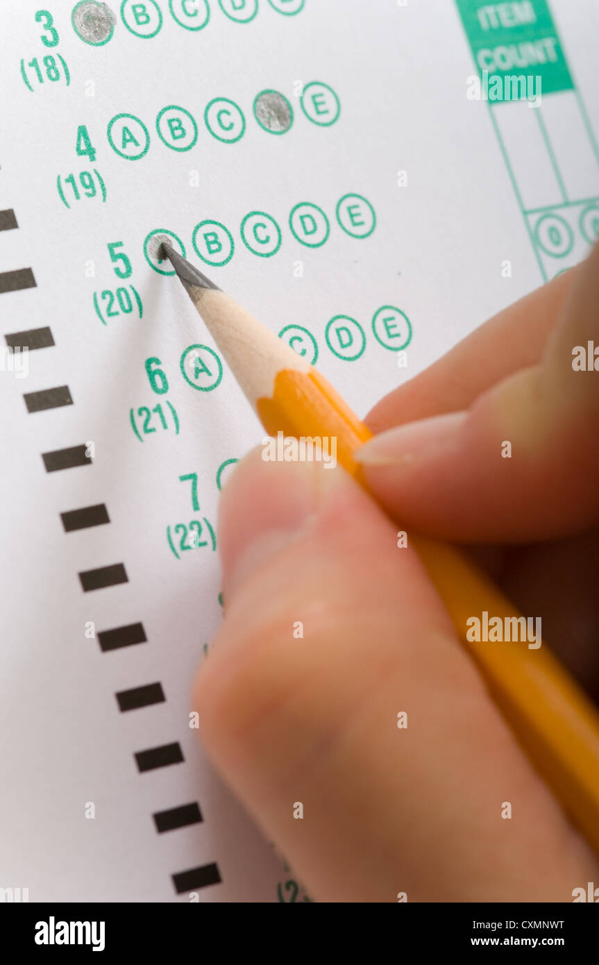 Female hand filling in a multiple choice examination answer sheet with ...