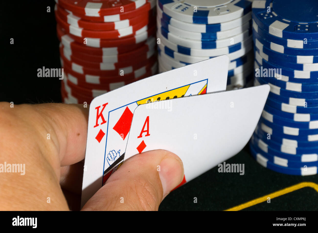Man's hand holding two playing card while gambling with several ...