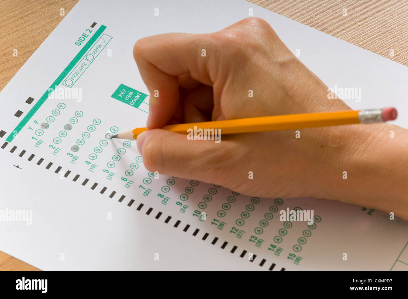 A female hand holding a pencil taking an examination using a multiple ...