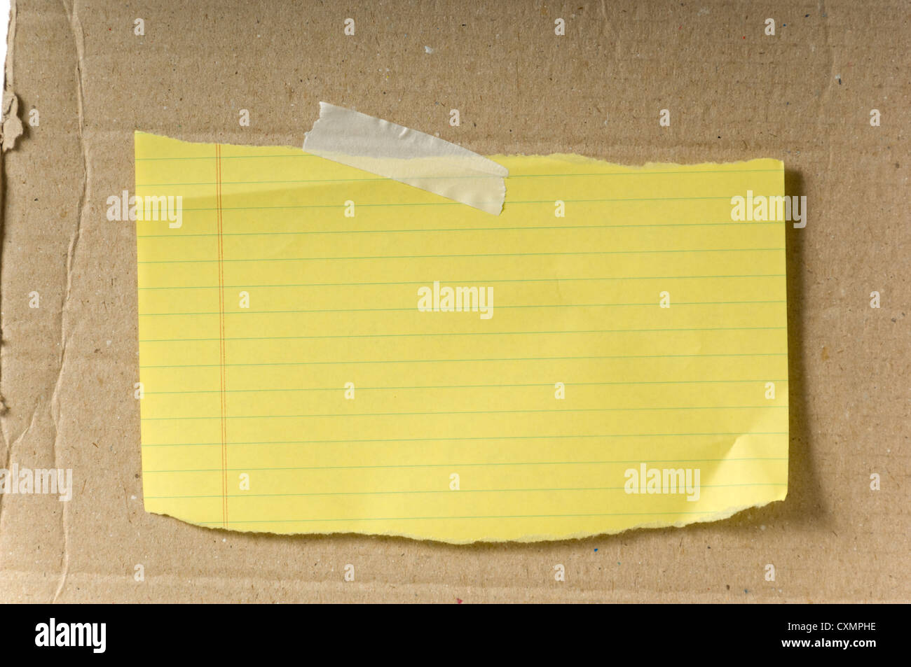Yellow blank paper taped to a piece of cardboard with copy space ...