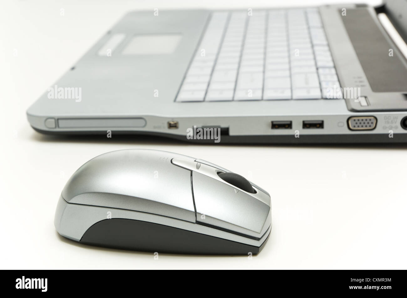 Close-up of silver laptop computer with a portable mouse, focus in on ...