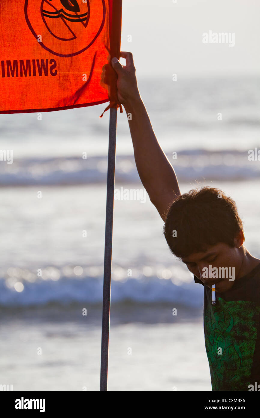 Red Warning Flag on Kuta Beach in Bali Stock Photo - Alamy