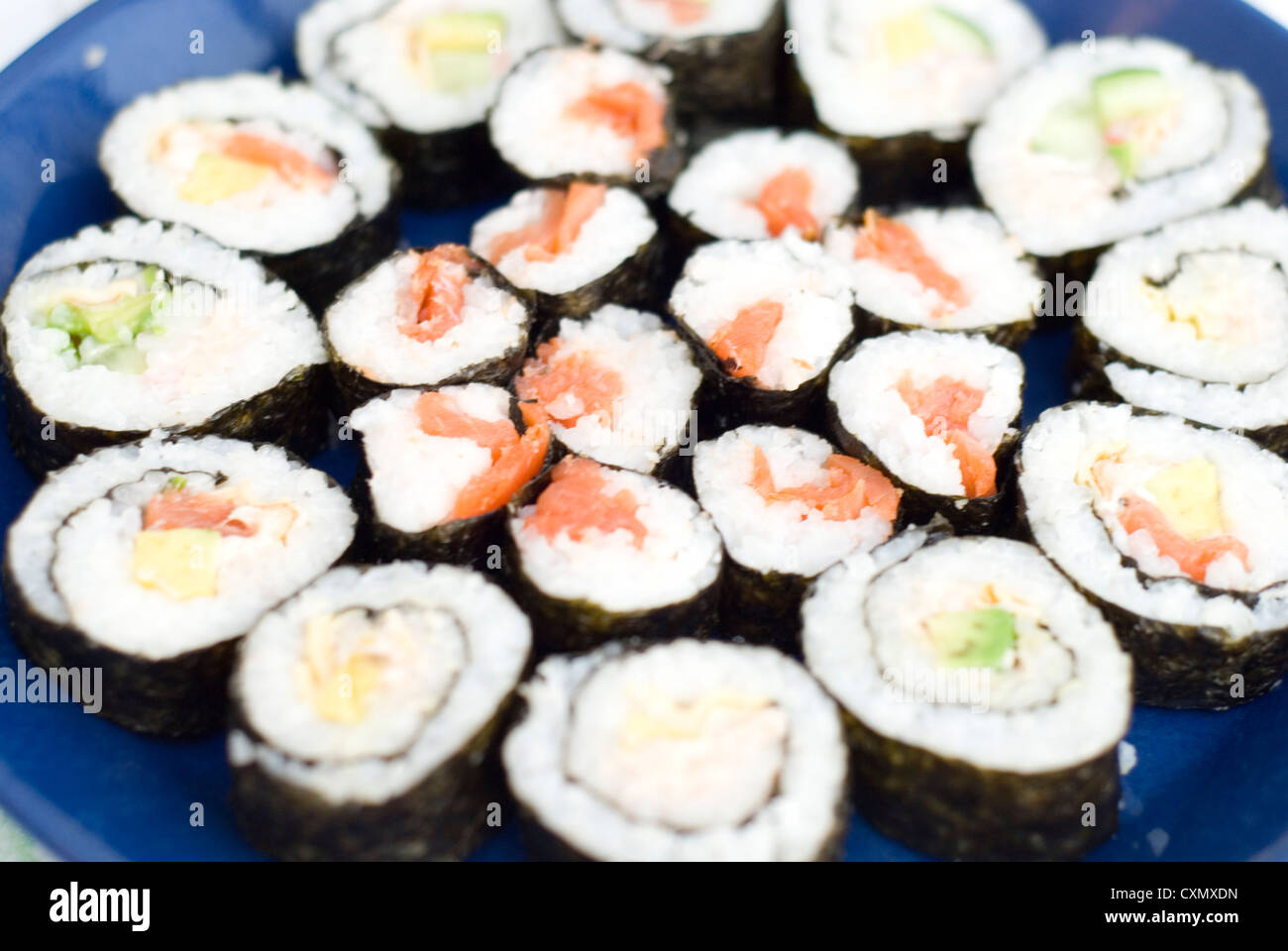 Different sizes of sushi rolls on a round and blue plate Stock Photo ...