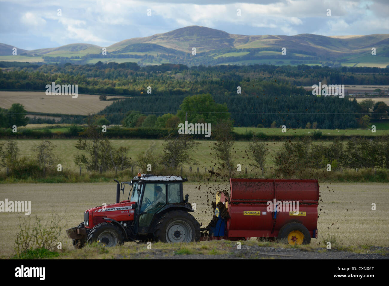 Farmer in tractor spreading manure Stock Photo - Alamy