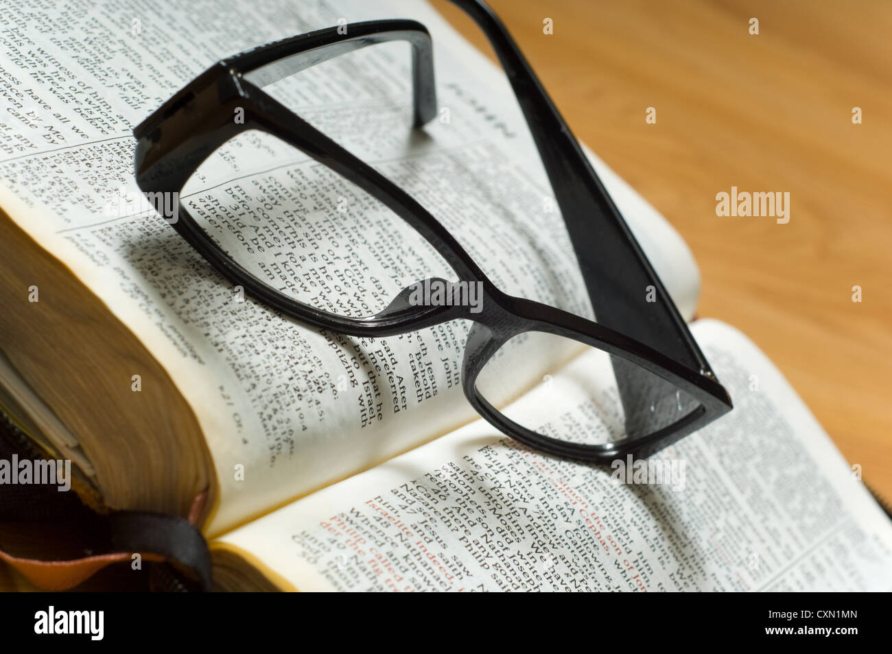 A pair of ladies reading glasses on top of a a Bible, religious study ...
