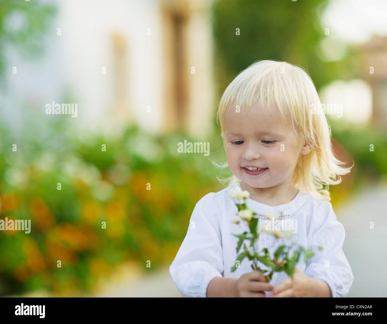 Portrait of baby with flowers outdoors Stock Photo - Alamy