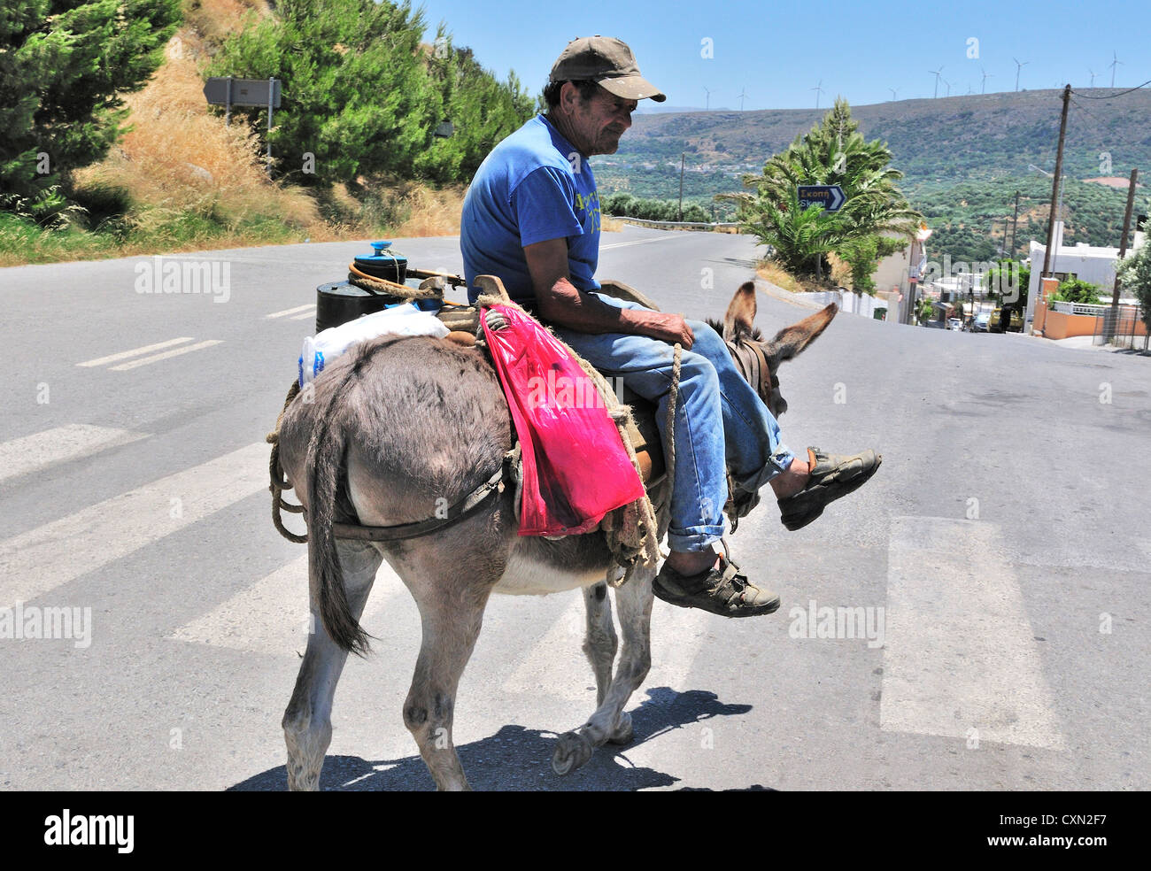 Man travelling on a donkey as means of his transport on a hlll top road ...
