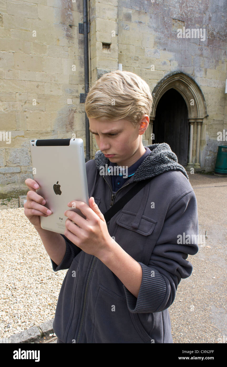 Young teenage boy with puzzled expression using an Apple iPad Stock ...