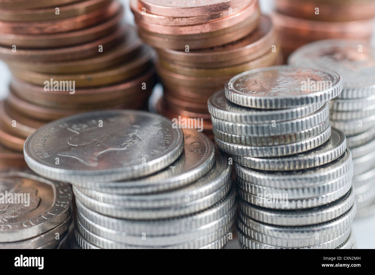 Piles of mixed silver & copper British coins stacked irregularly ...