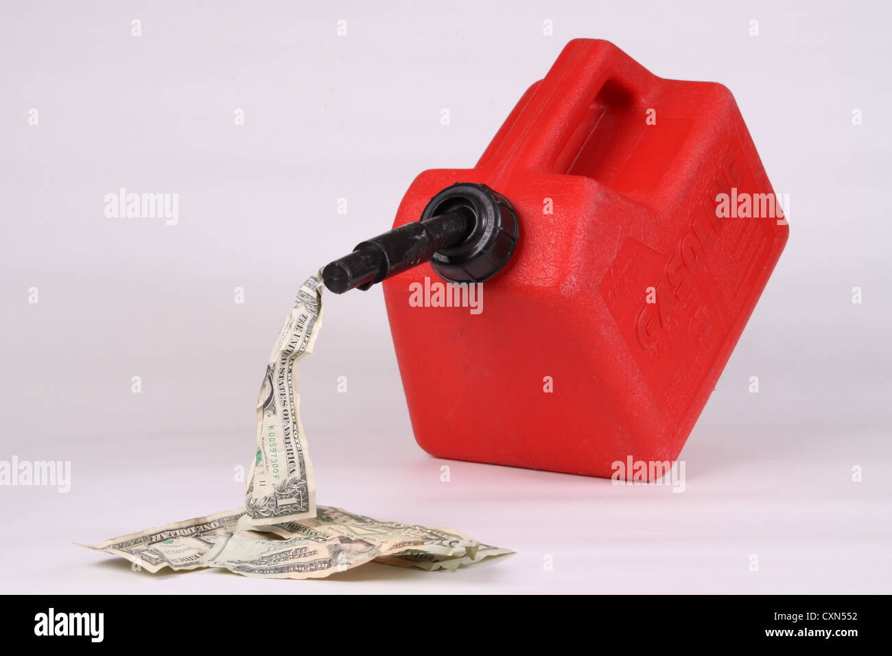 Red gasoline can spilling out U.S. currency Stock Photo - Alamy