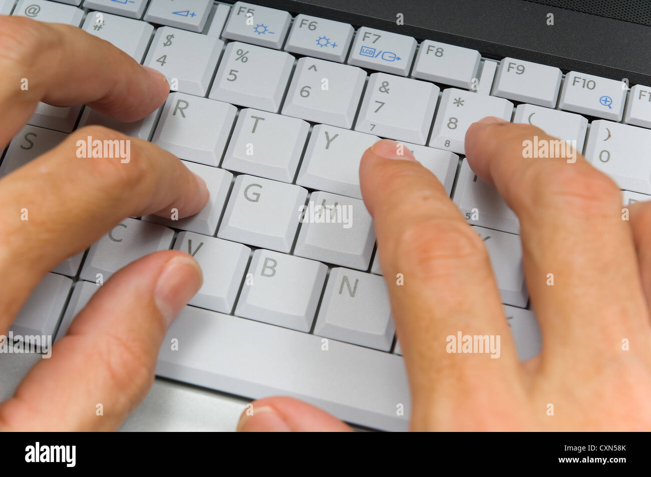 White or Caucasian male hands typing on laptop computer keyboard- focus ...
