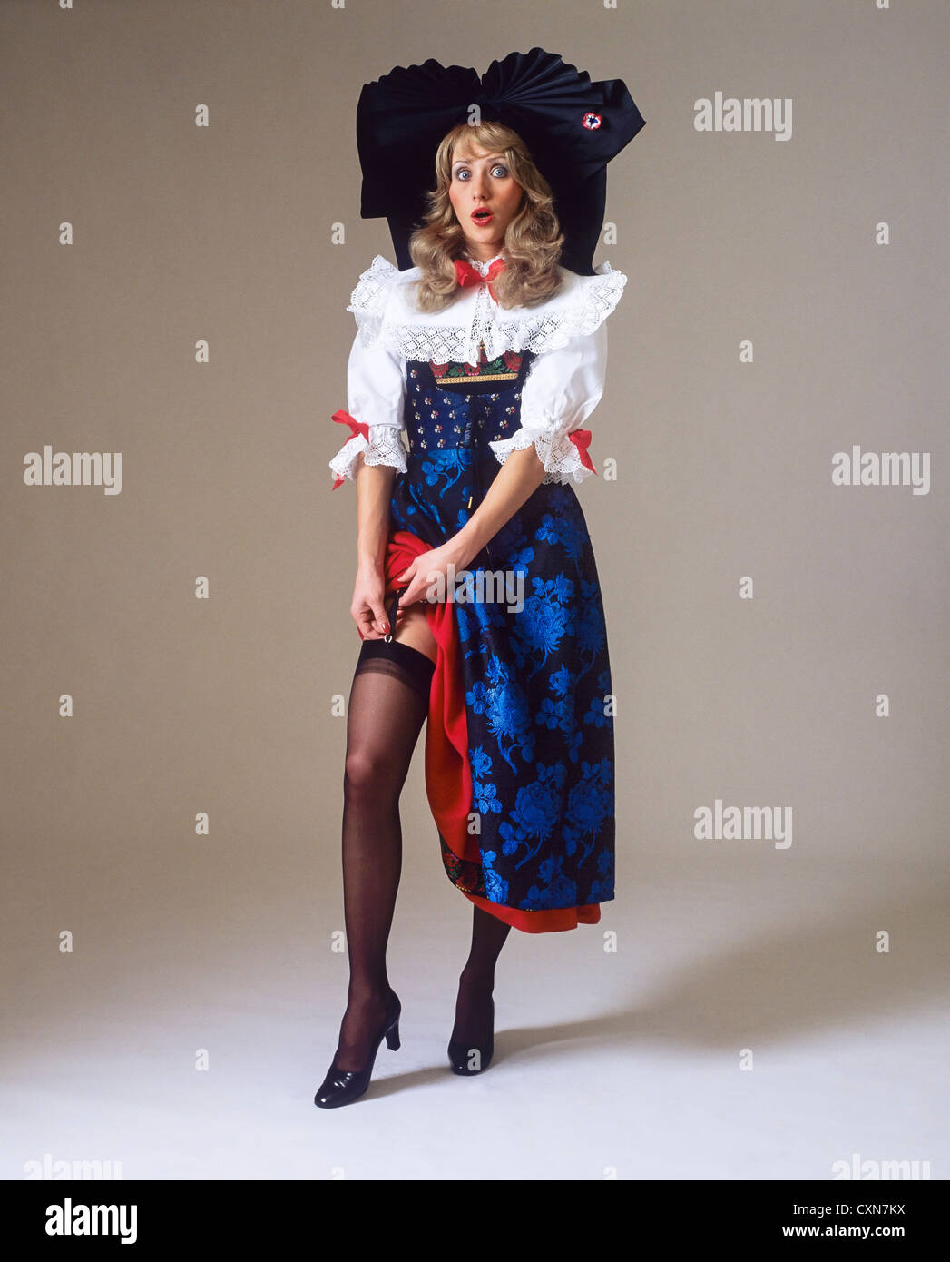 Woman with traditional Alsatian folk costume adjusting her garter belt ...