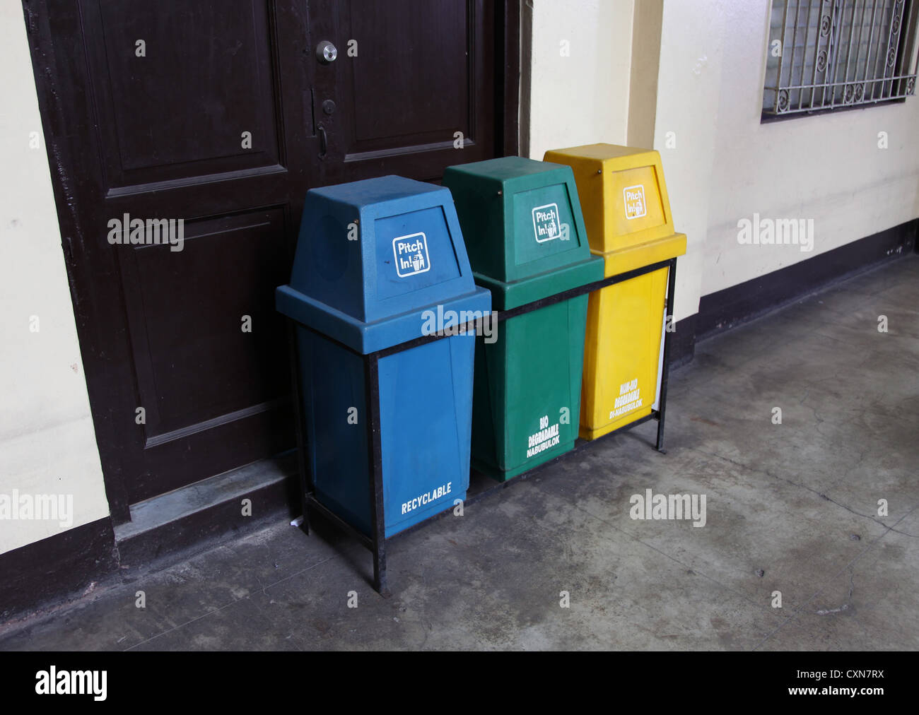It's a photo of 3 recycle bins side by side. One for paper, One for ...