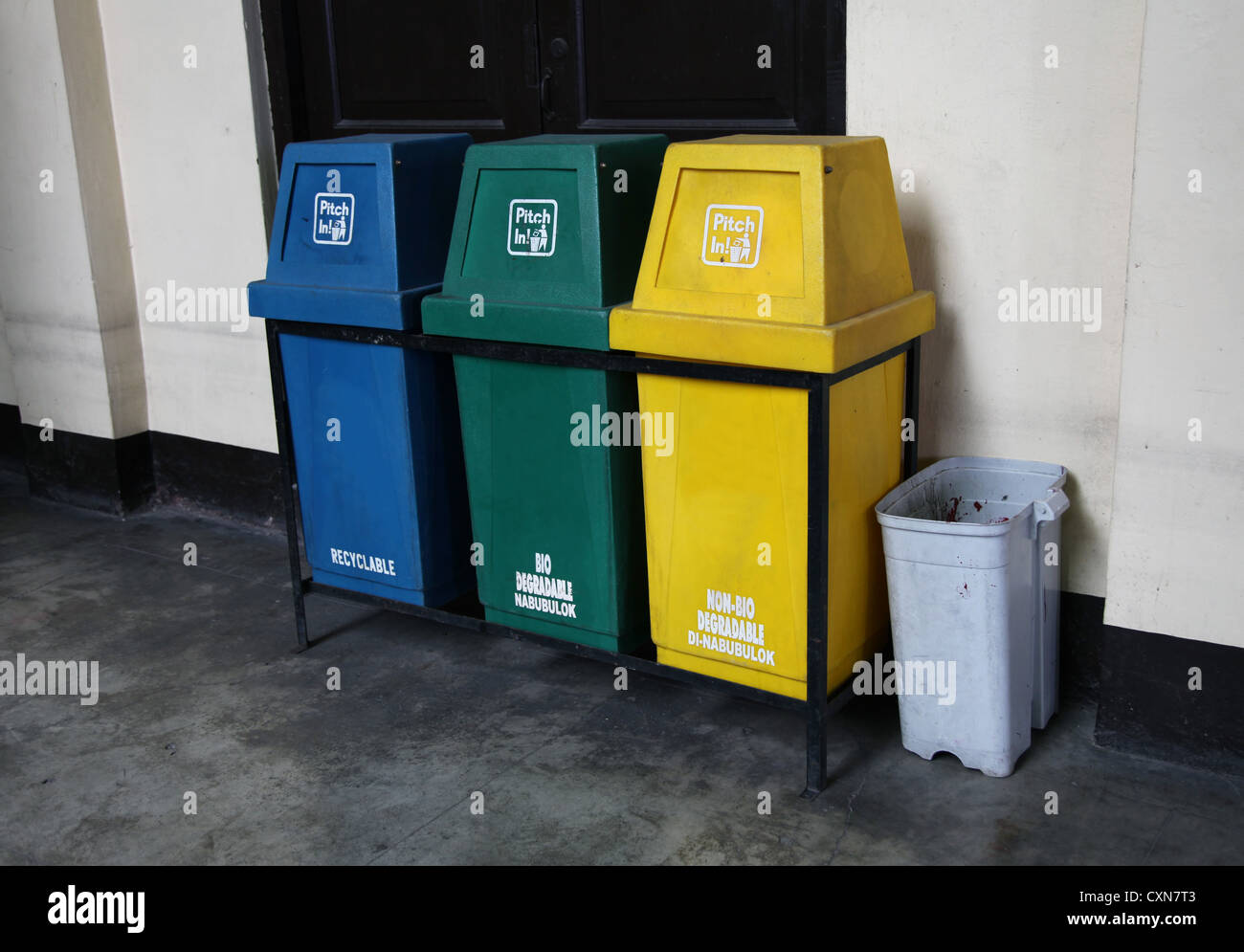 It's a photo of 3 recycle bins side by side. One for paper, One for ...