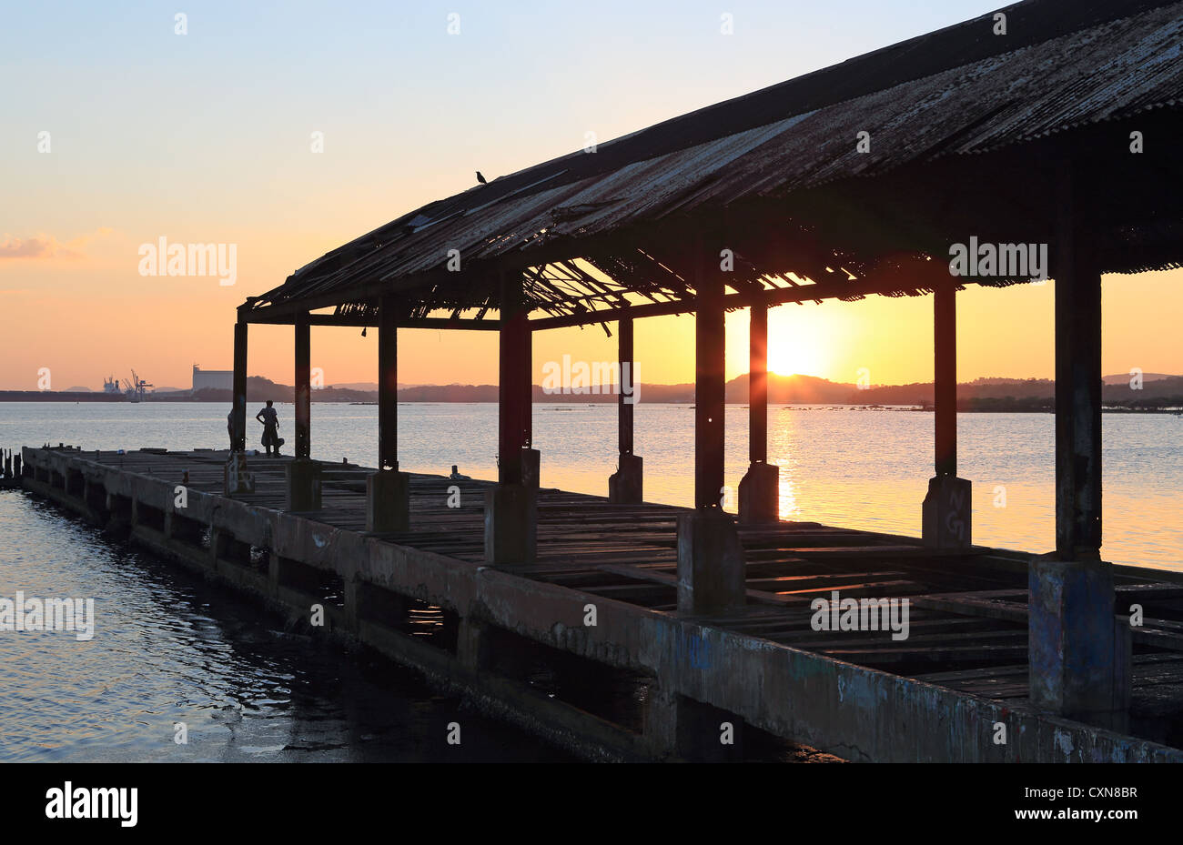 Men fishing off old wooden pier at sunset in Trincomalee harbor, Sri ...