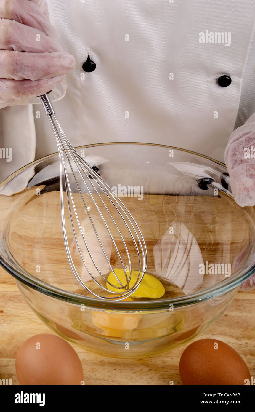 female chef in uniform holding a whisk Stock Photo - Alamy