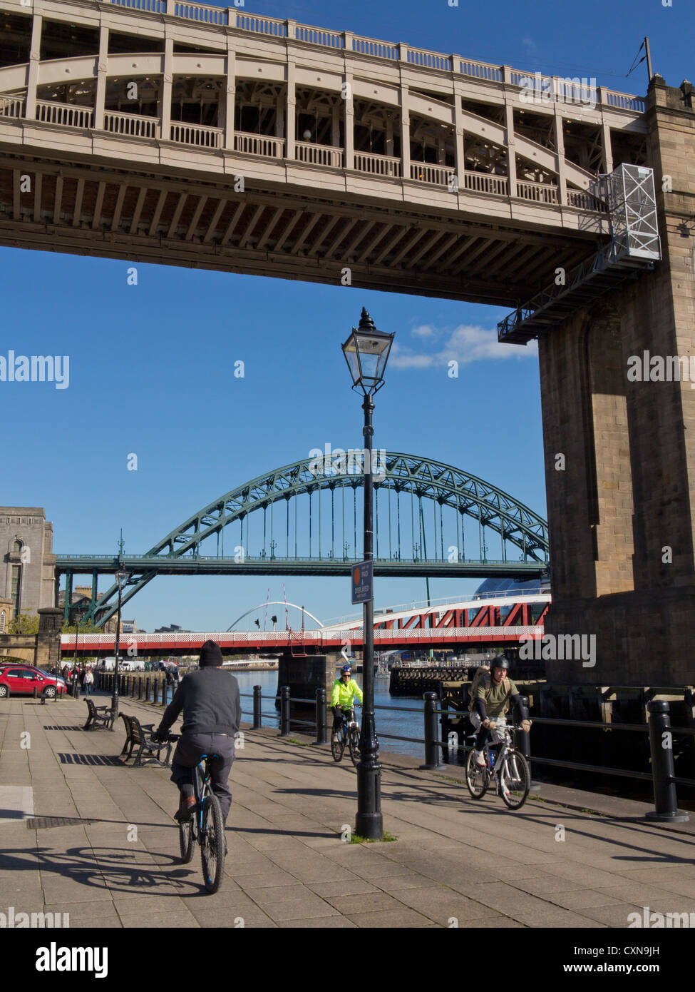 People walk and cycle on riverside by Tyne bridges in Newcastle ...