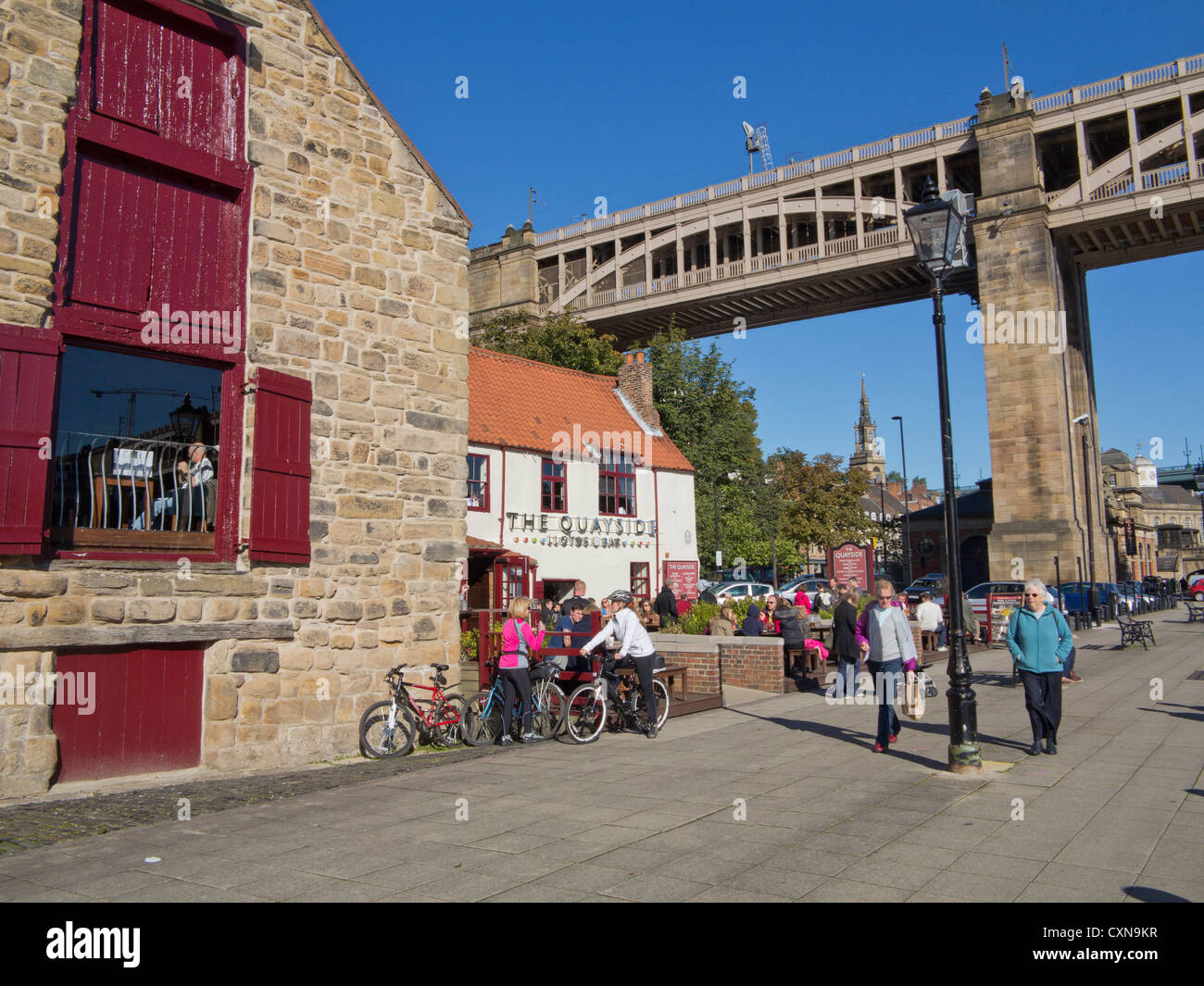 People walk and cycle on riverside by Tyne bridges in Newcastle ...