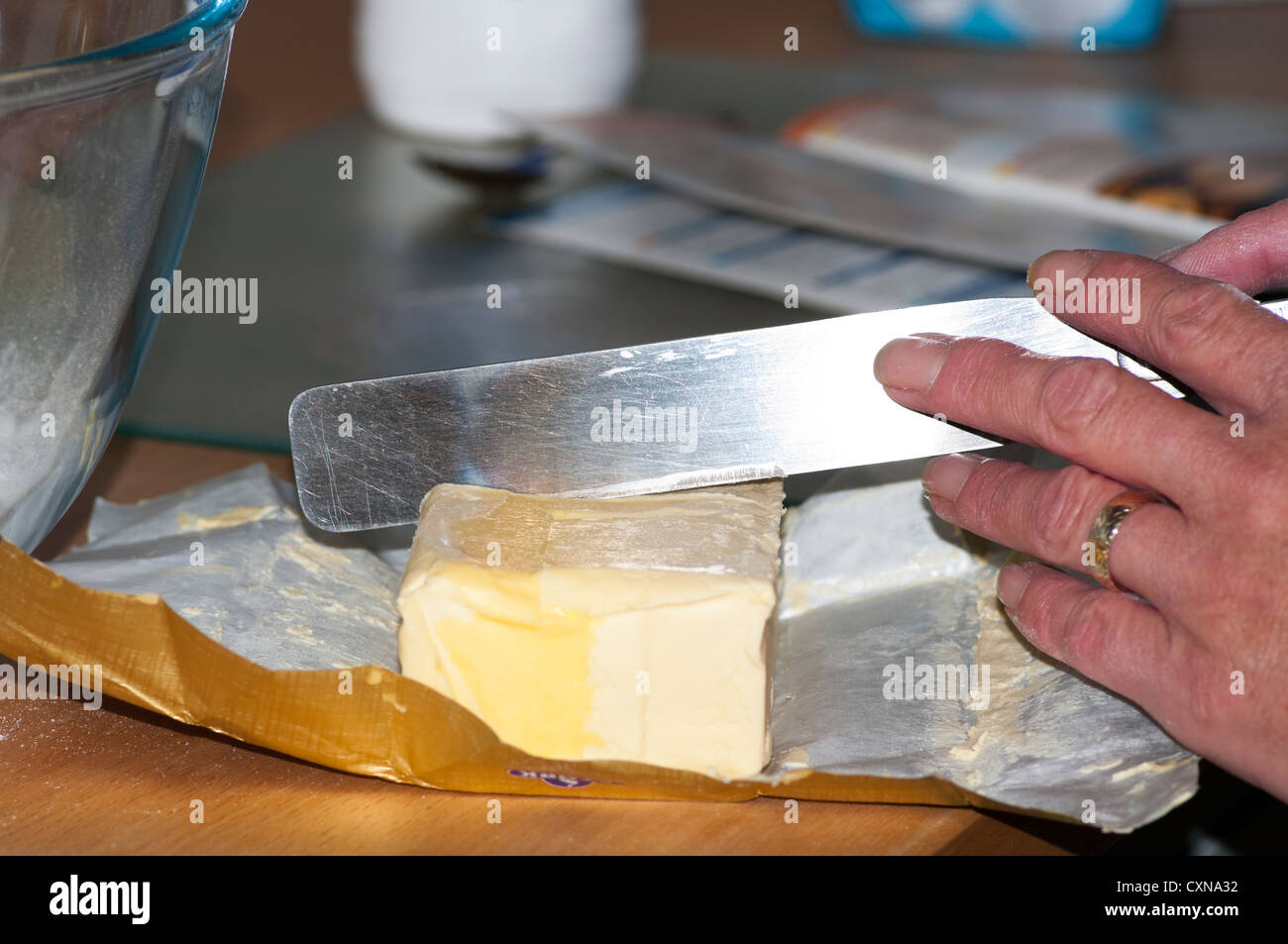 Woman Cutting A Slice Of Butter Whilst Home Baking Stock Photo - Alamy