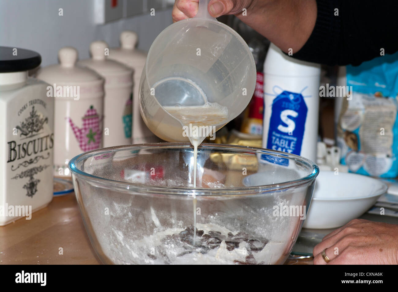 Cook Adding Milk and Egg To A Cake Mix In A Bowl Home Baking Stock ...
