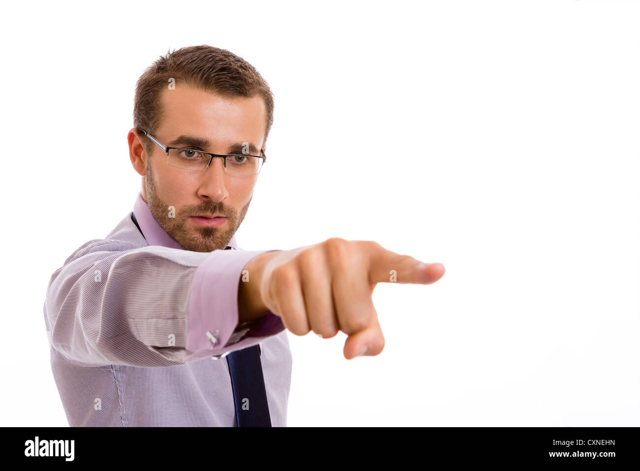 Serious young businessman pointing at something over white background ...