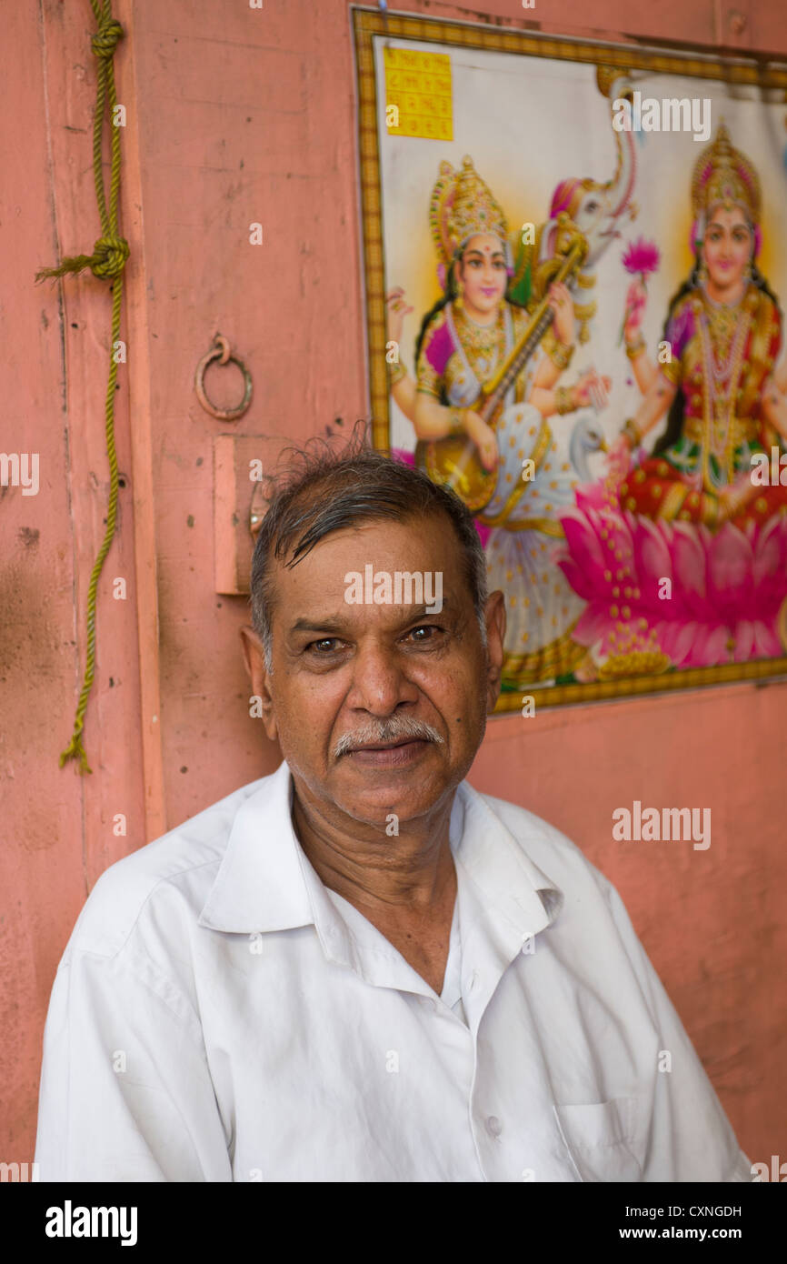 Spice trader in front of a religious poster, in an alley of Khari Baoli ...