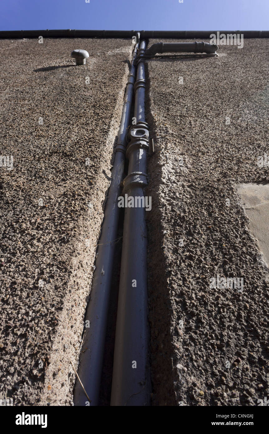 Drainpipe deeply recessed into wall where new finish has been added ...