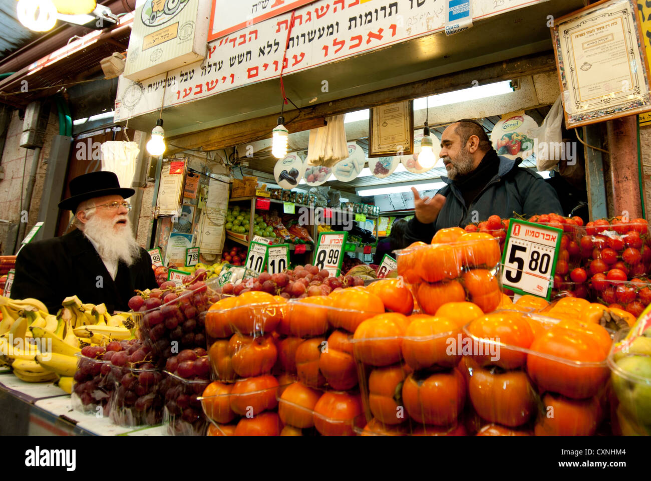Israel, Jerusalem, orthodox Jewish man talking to a fruit store owner ...