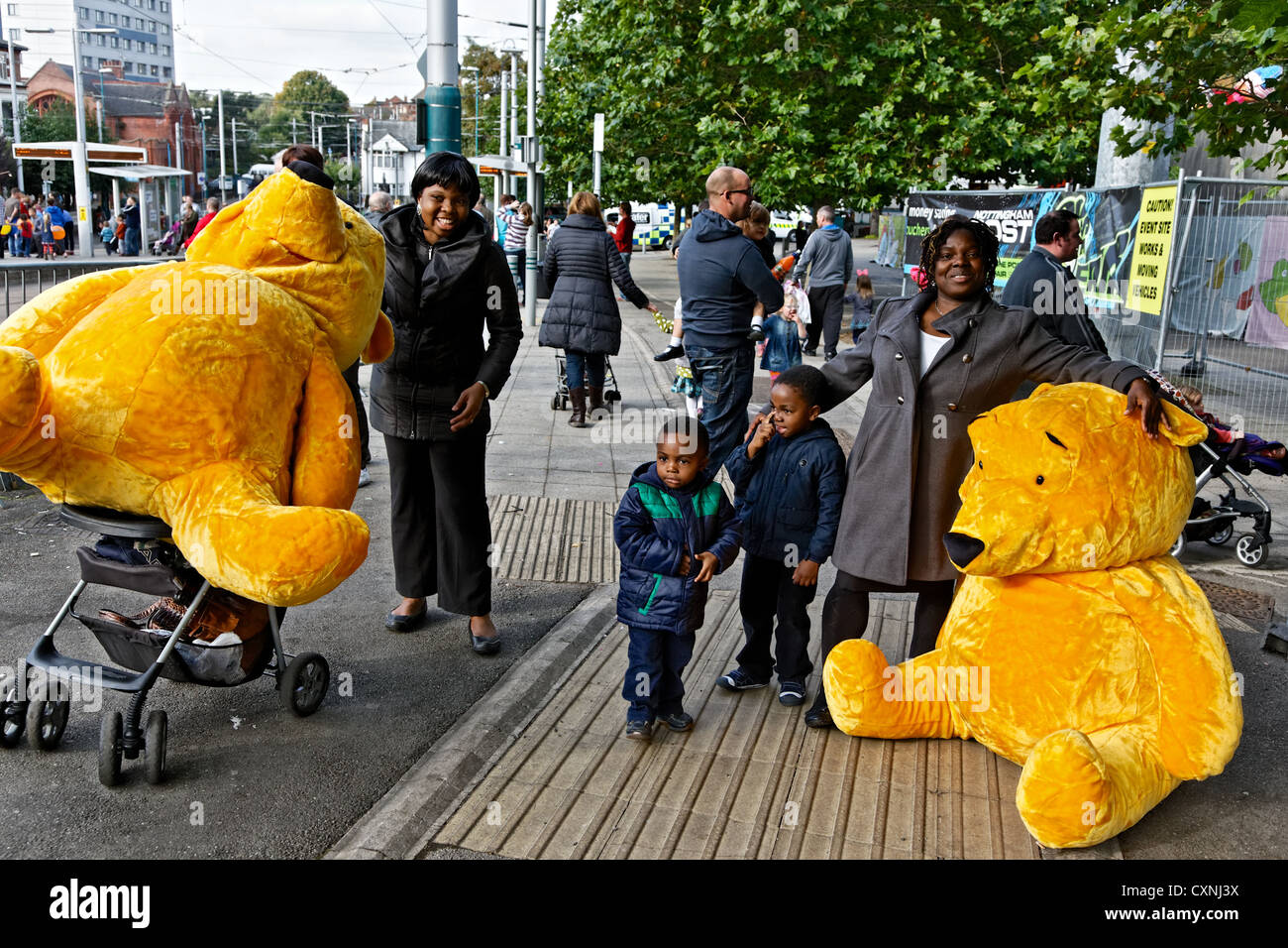 Two lucky prizewinners carry their giant teddy bear prizes at ...