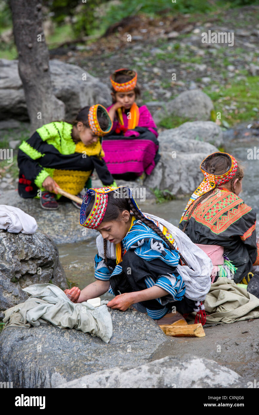 Kalash girls washing clothes in the stream running through the village ...