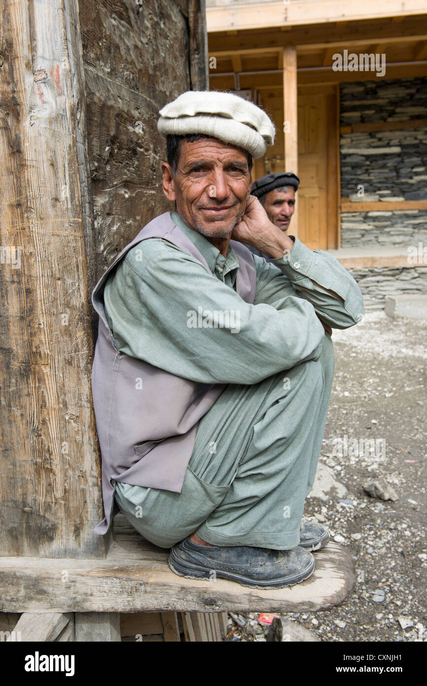 Kalash men squatting on a wooden ledge in the village of Balanguru ...
