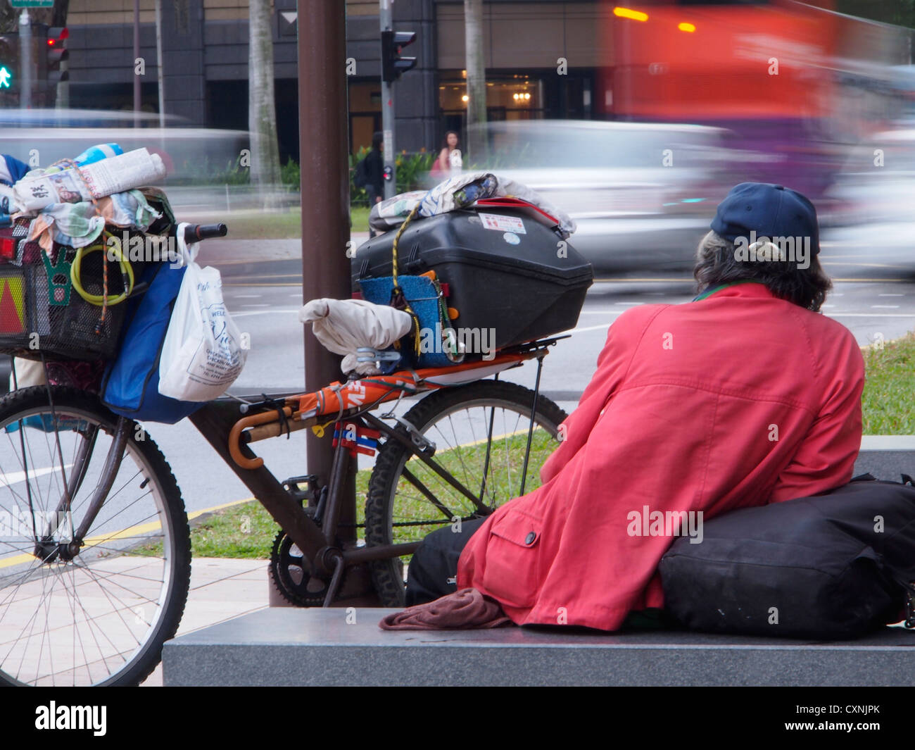 A homeless man watches life go by in the Arab street area of Singapore ...