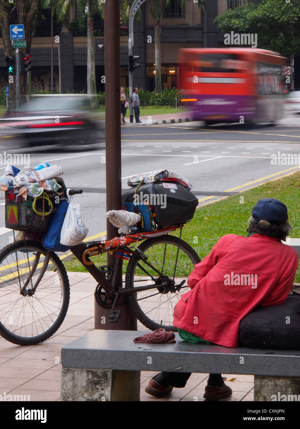 A homeless man watches life go by in the Arab street area of Singapore ...