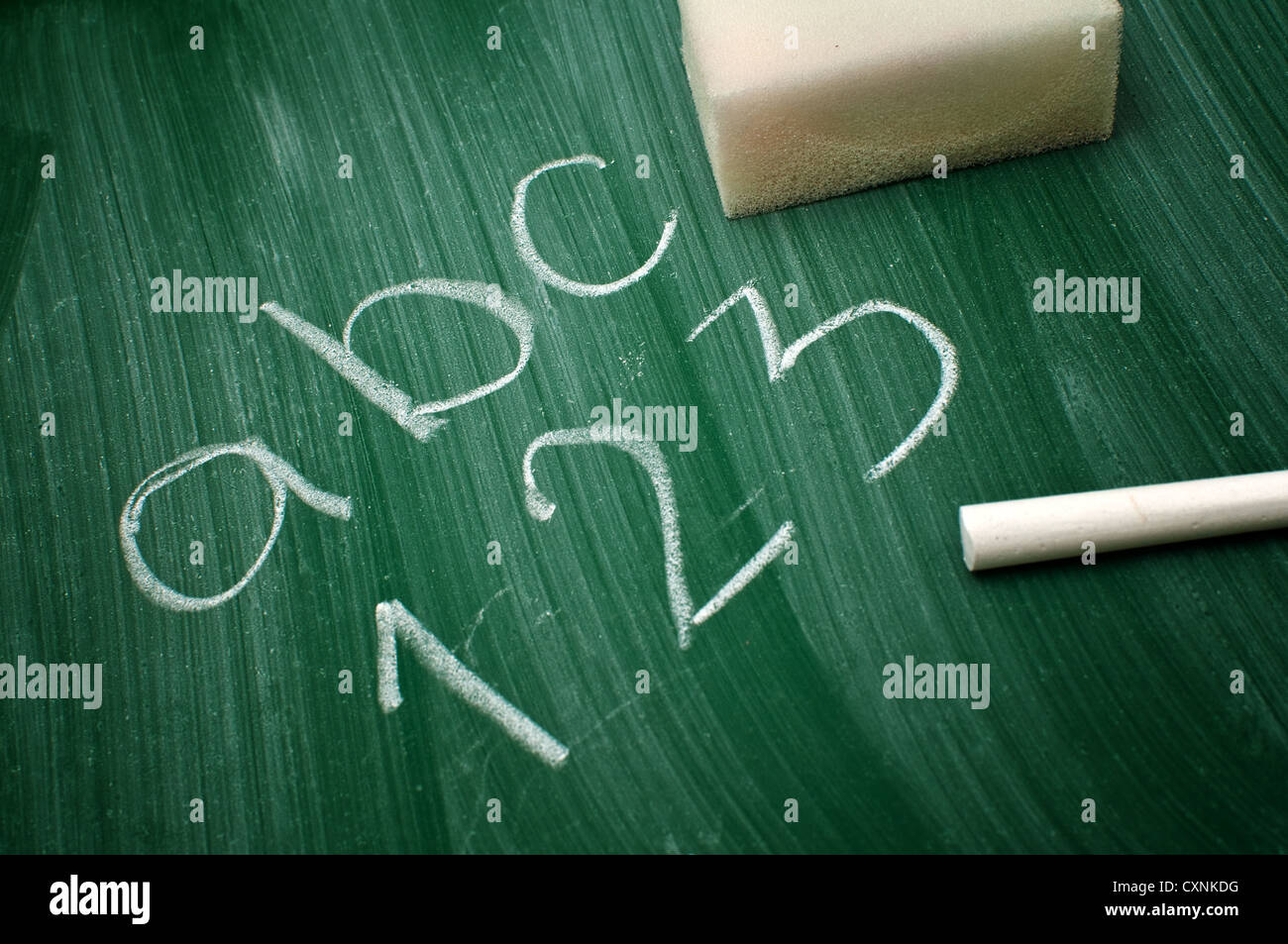 Learning numbers and letters, chalk and sponge on green chalkboard ...