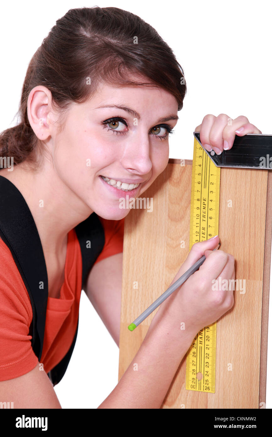 Female carpenter marking out wood with set-square Stock Photo - Alamy