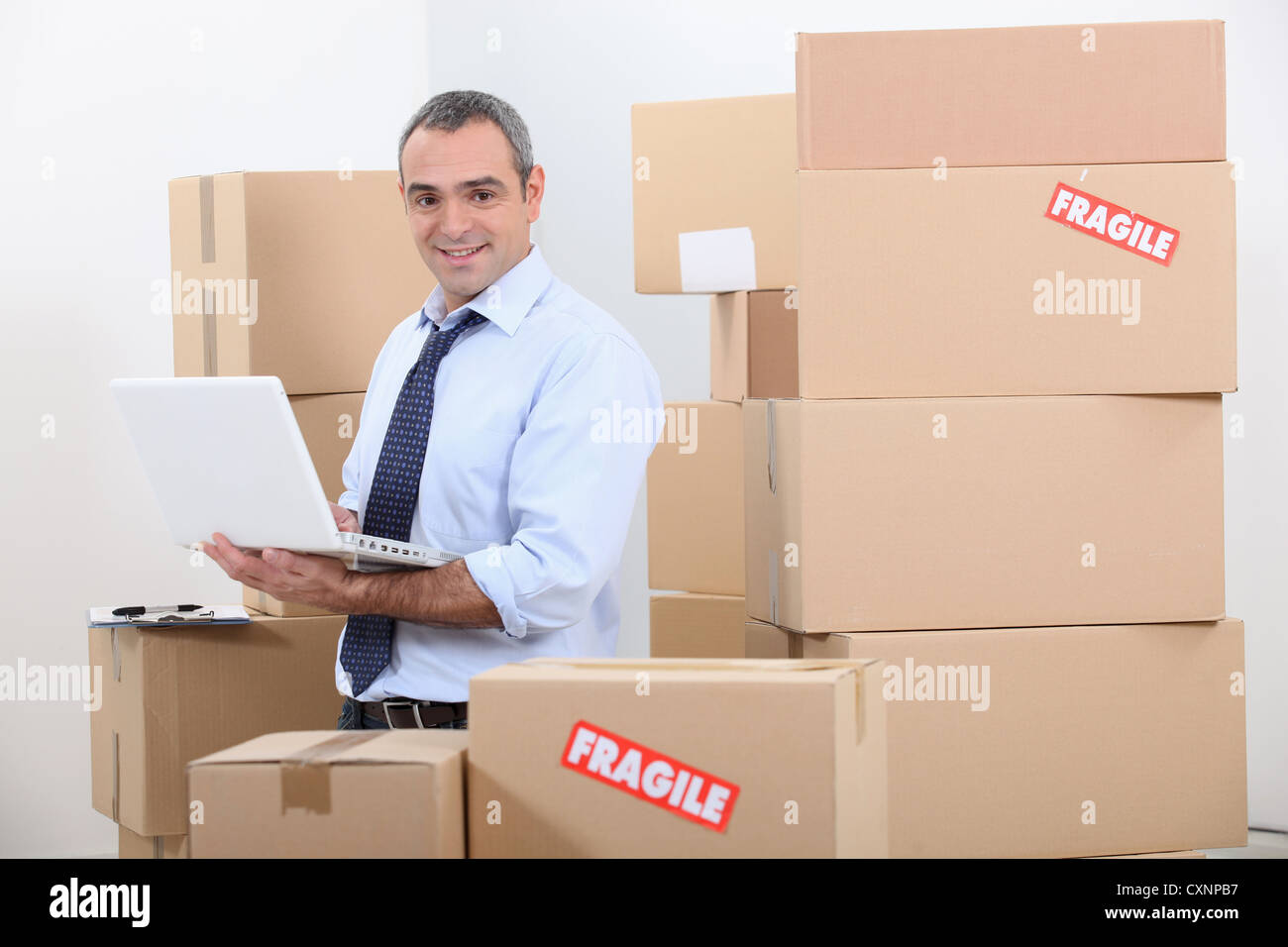 Man in suit surrounded by stacks of boxes Stock Photo - Alamy