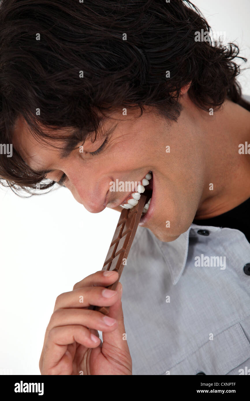 Man eating chocolate bar Stock Photo - Alamy