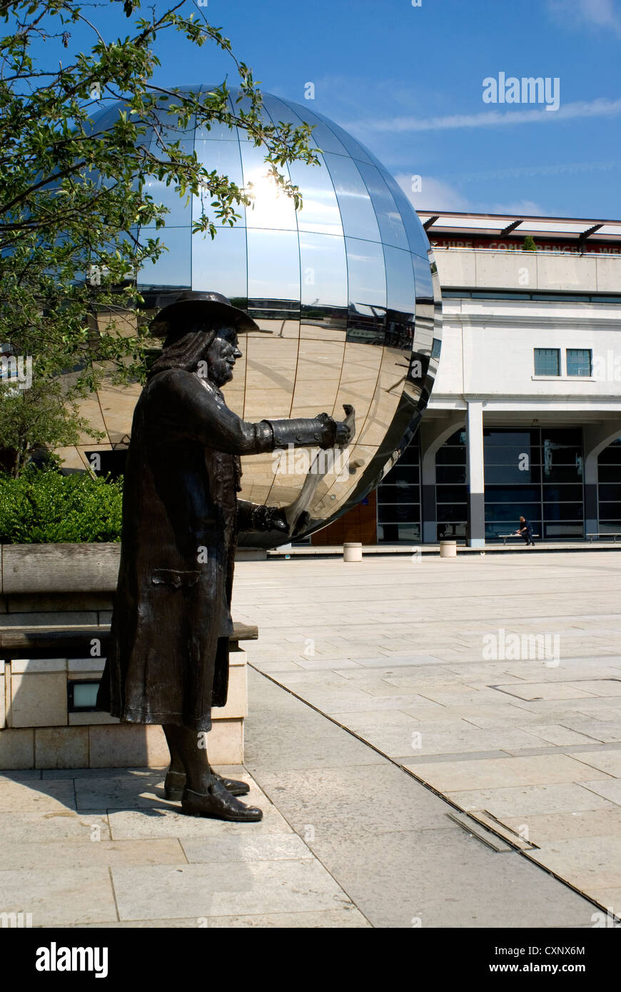 A statue of a merchant and the Millennium Sphere in Millennium Square ...