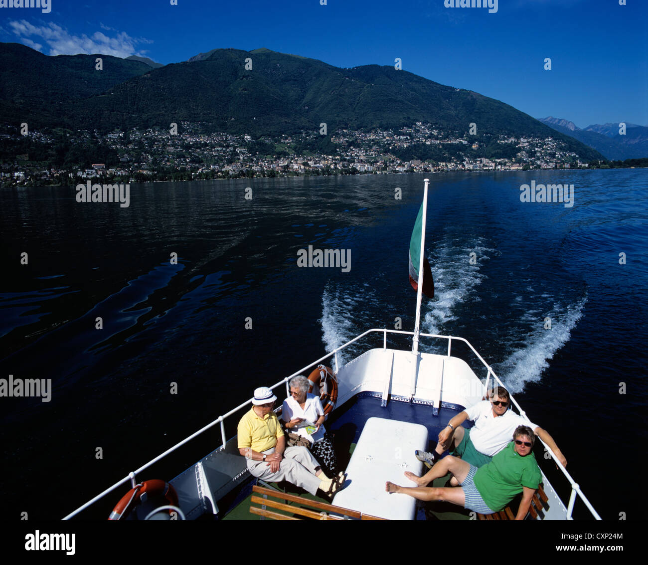 Switzerland. Ticino. View of Locarno and people seated at stern of ...