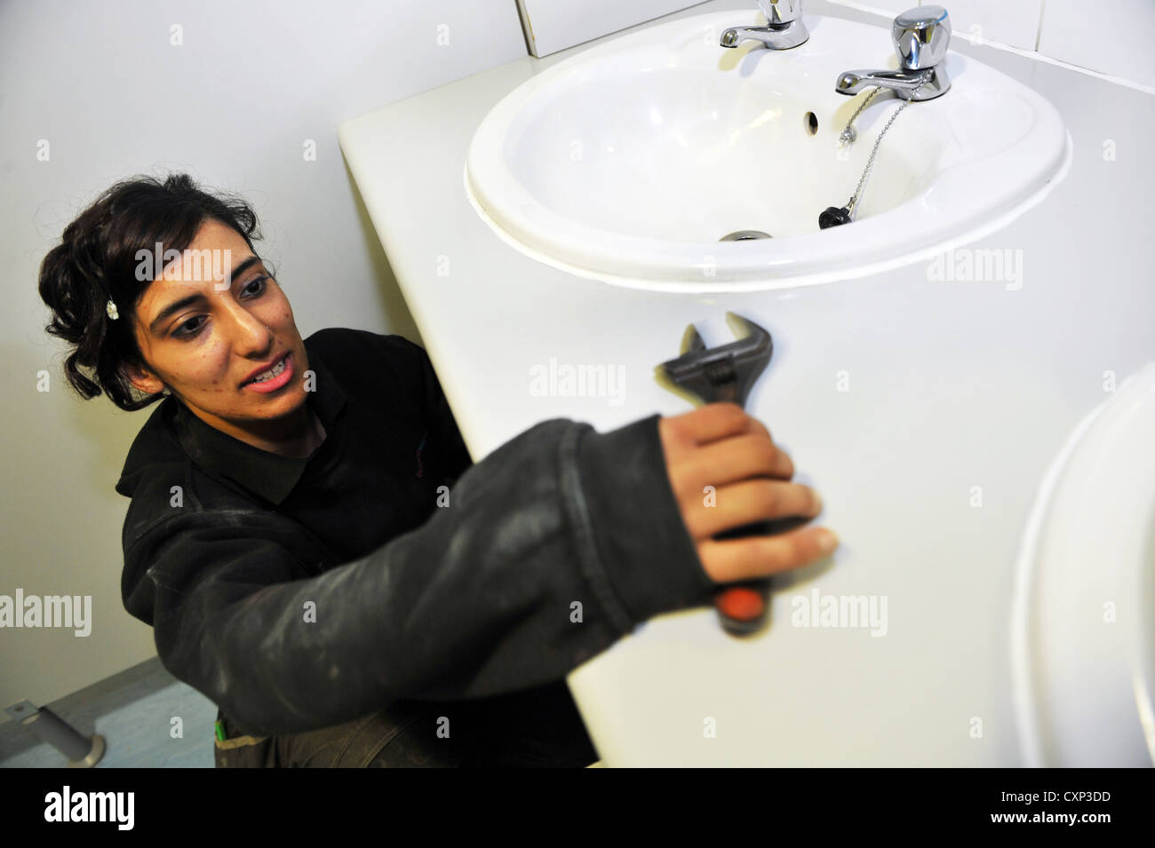 A Young female Plumbing Apprentice practices at a training centre in ...