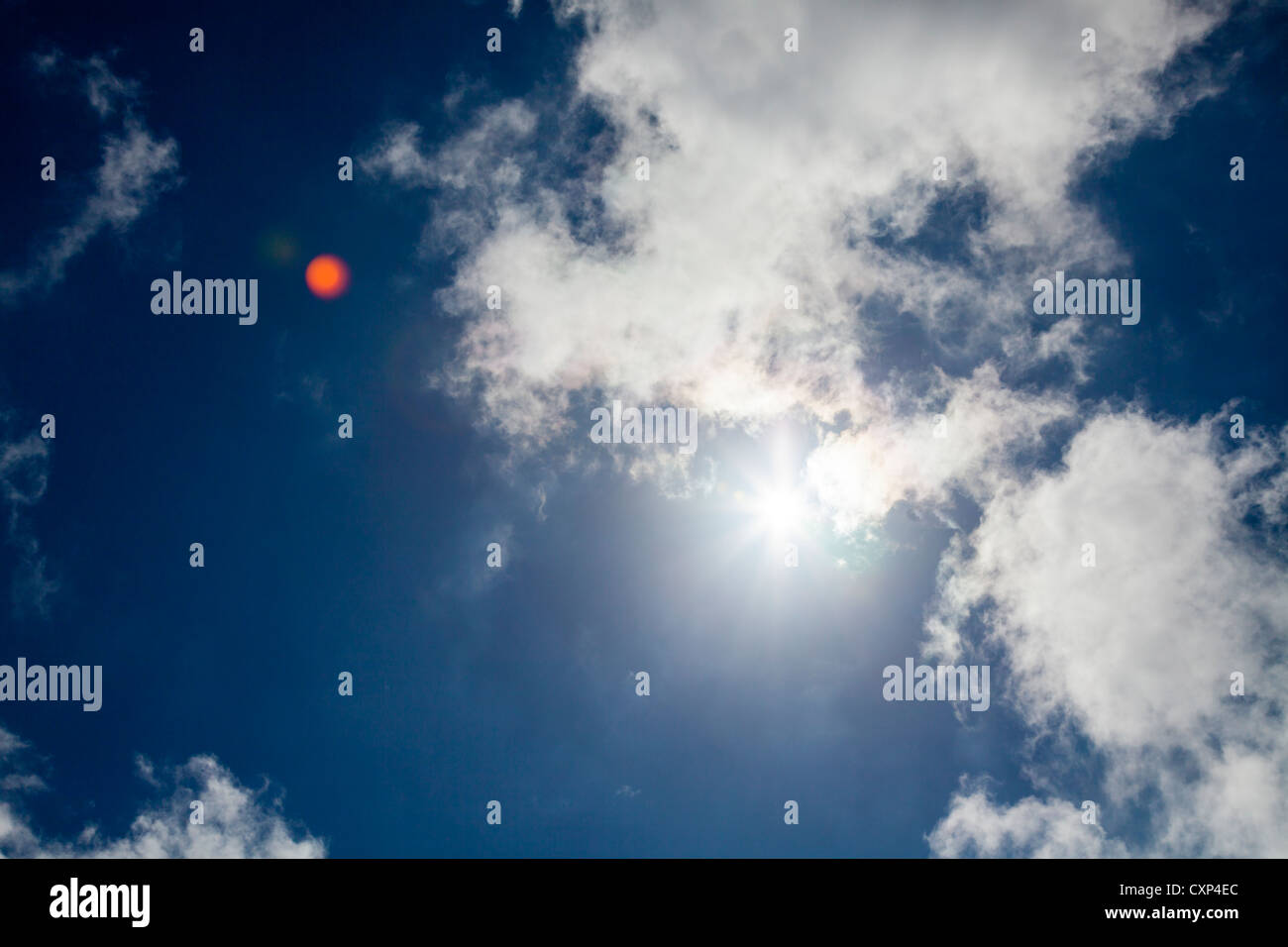 sun and light wispy cloud with blue sky with lens flare Stock Photo - Alamy