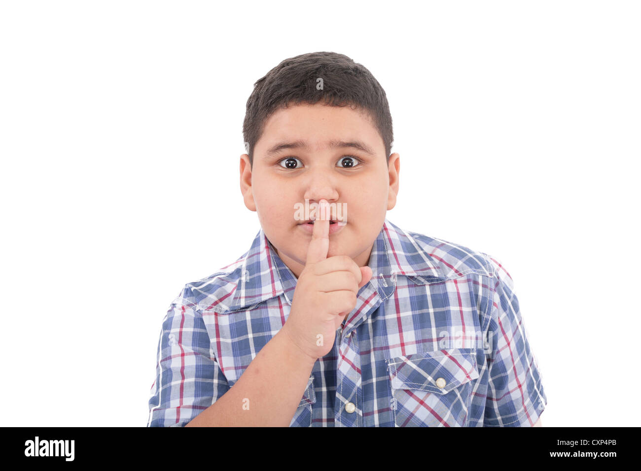 Portrait of beautiful little boy with silence gesture over white ...