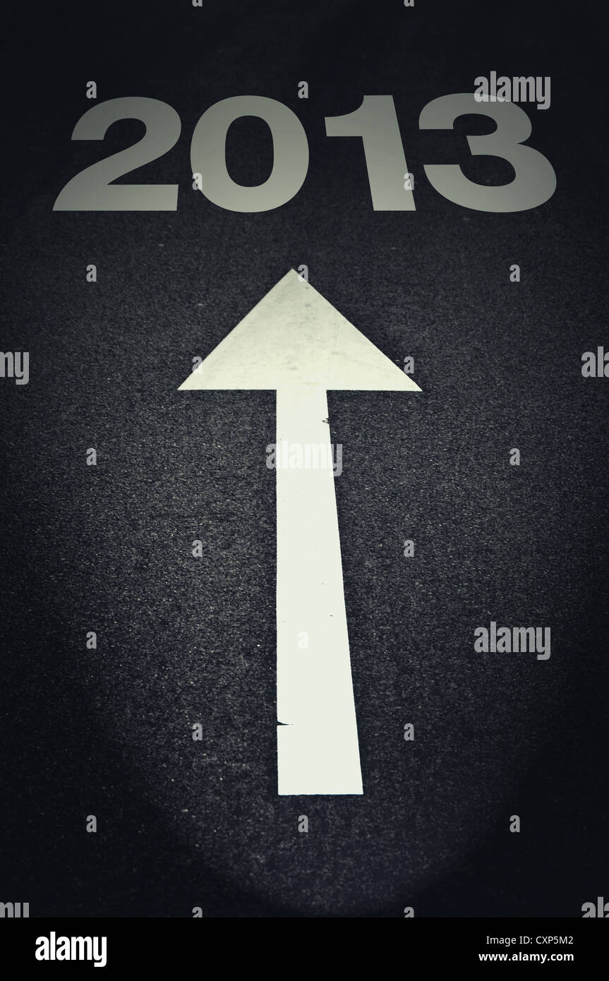 Towards new year of 2013, arrow sign on the road lit by the car light ...