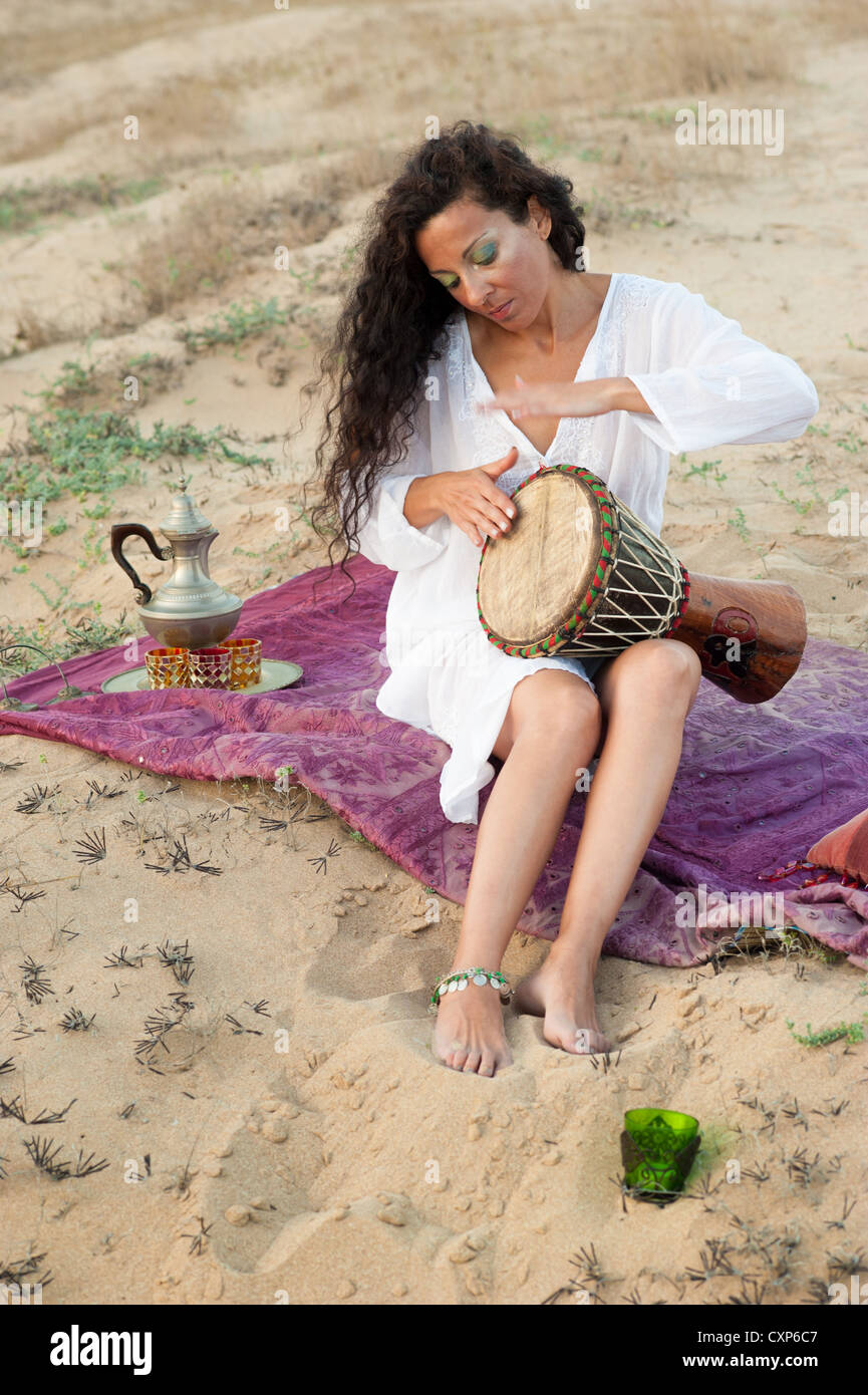 Female playing a djembe in an African setting Stock Photo - Alamy