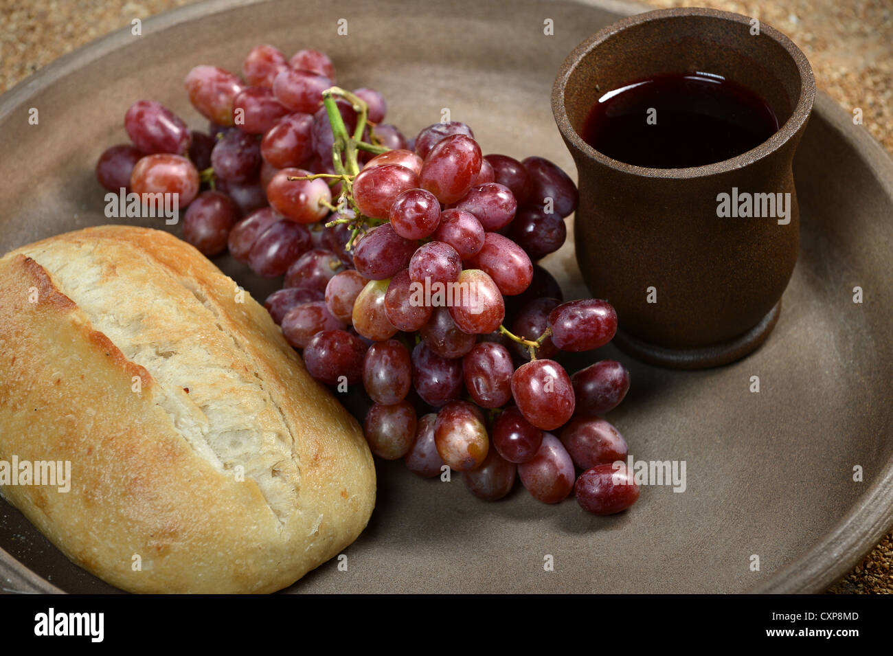 Tray with bread, red grapes and cup of wine symbolizing the body and ...