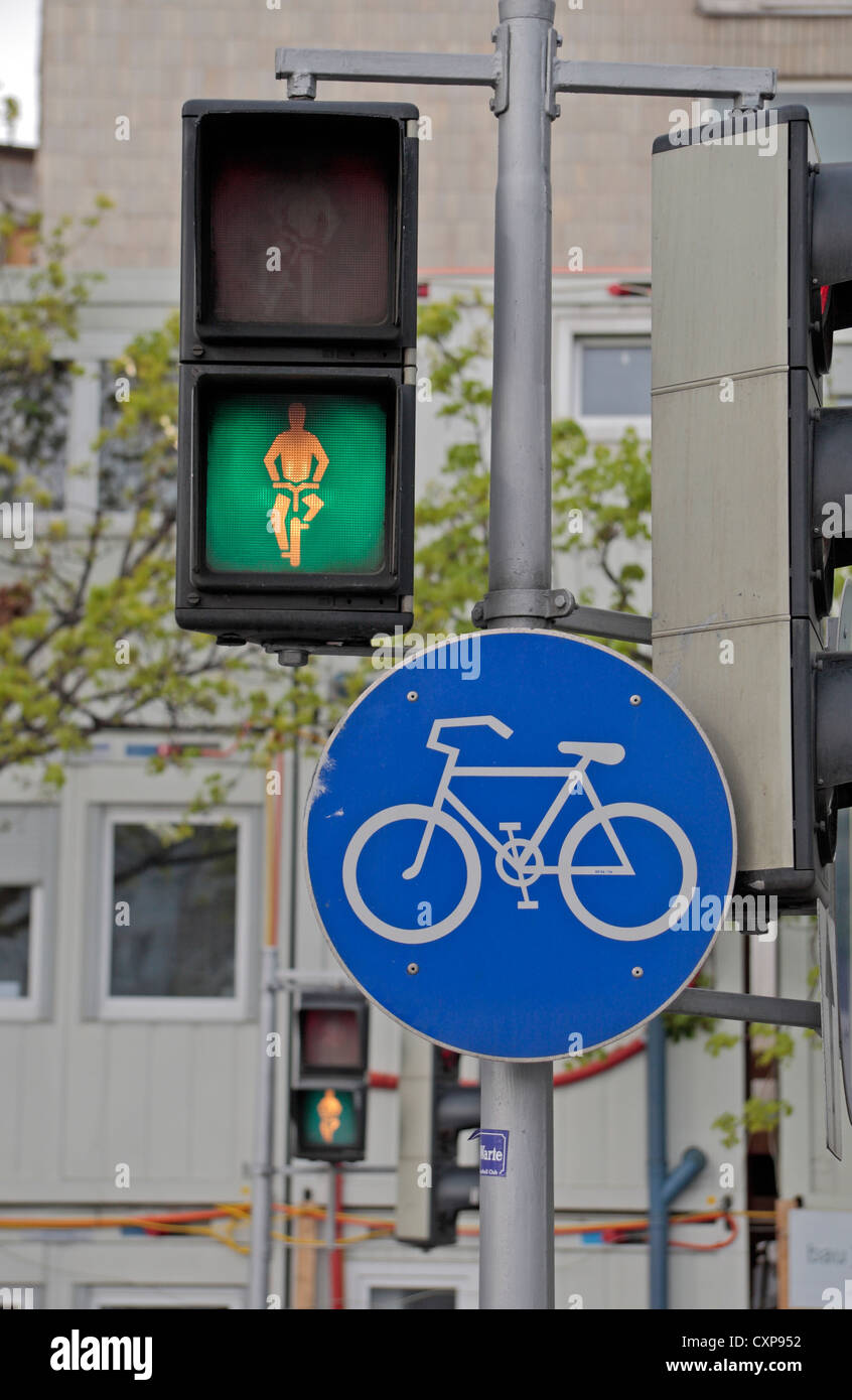 Detail showing a blue cycling sign beside a green crossing light at a ...