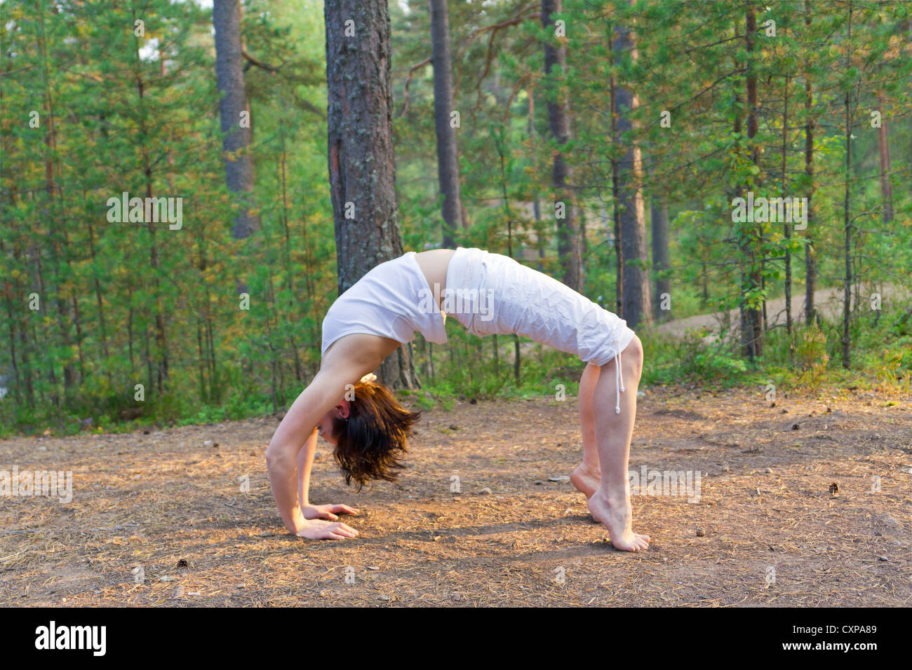 Woman in yoga bow pose in forest Stock Photo - Alamy